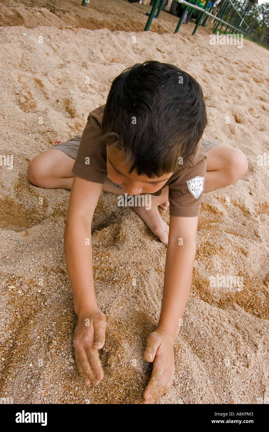 Boy playing in the sand Stock Photo - Alamy