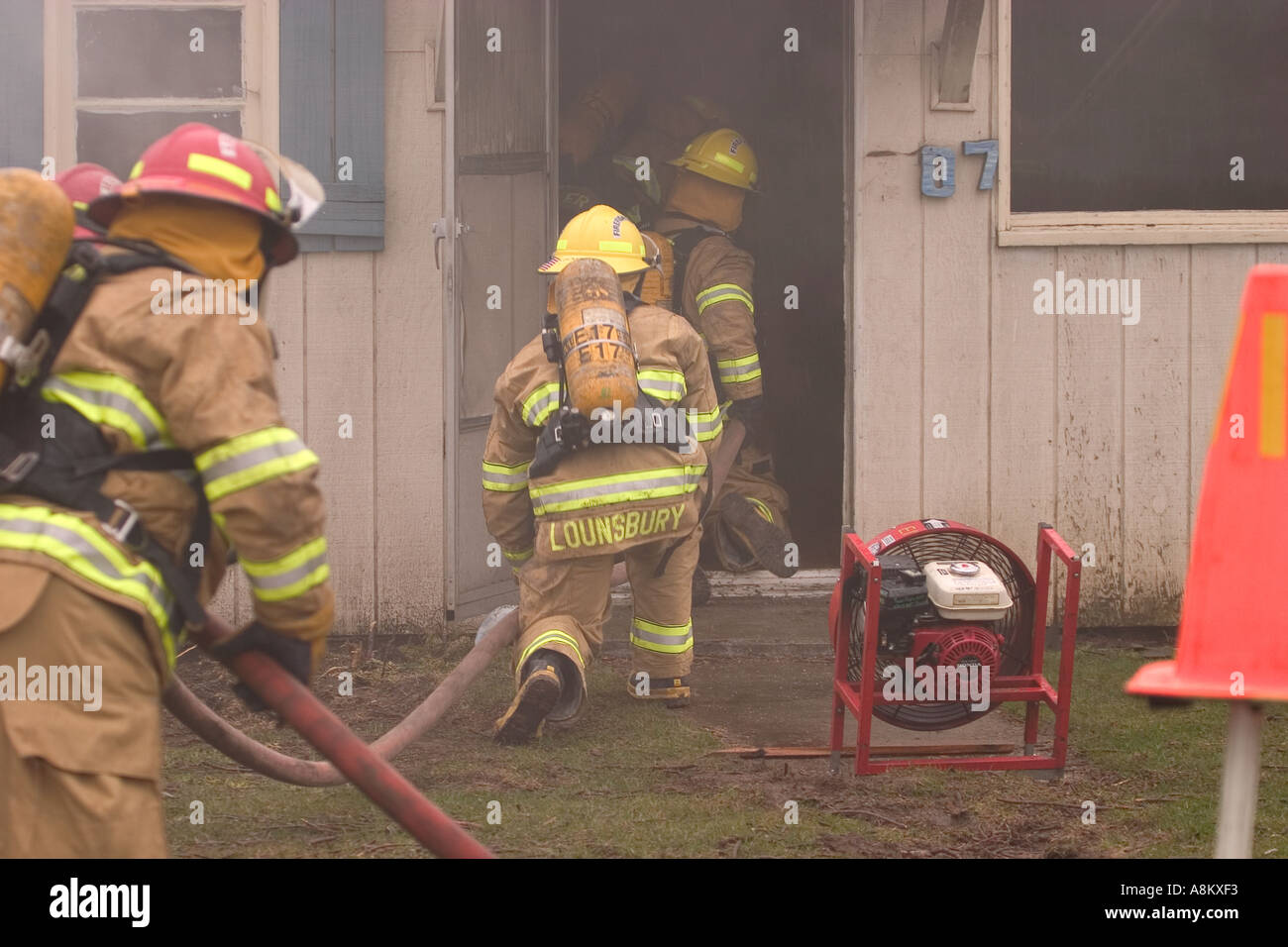 Firemen at a training session entering a house with smoke inside Stock ...
