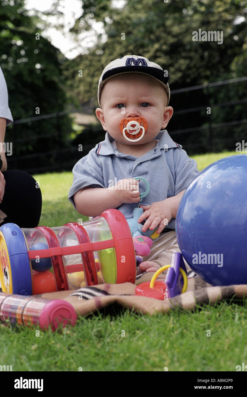 a young boy playing in the park with a dummy in his mouth Stock Photo ...