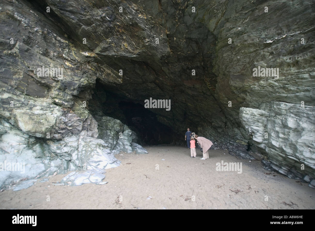 People in the mouth of Merlins Cave in the cliff beneath Tintagel ...