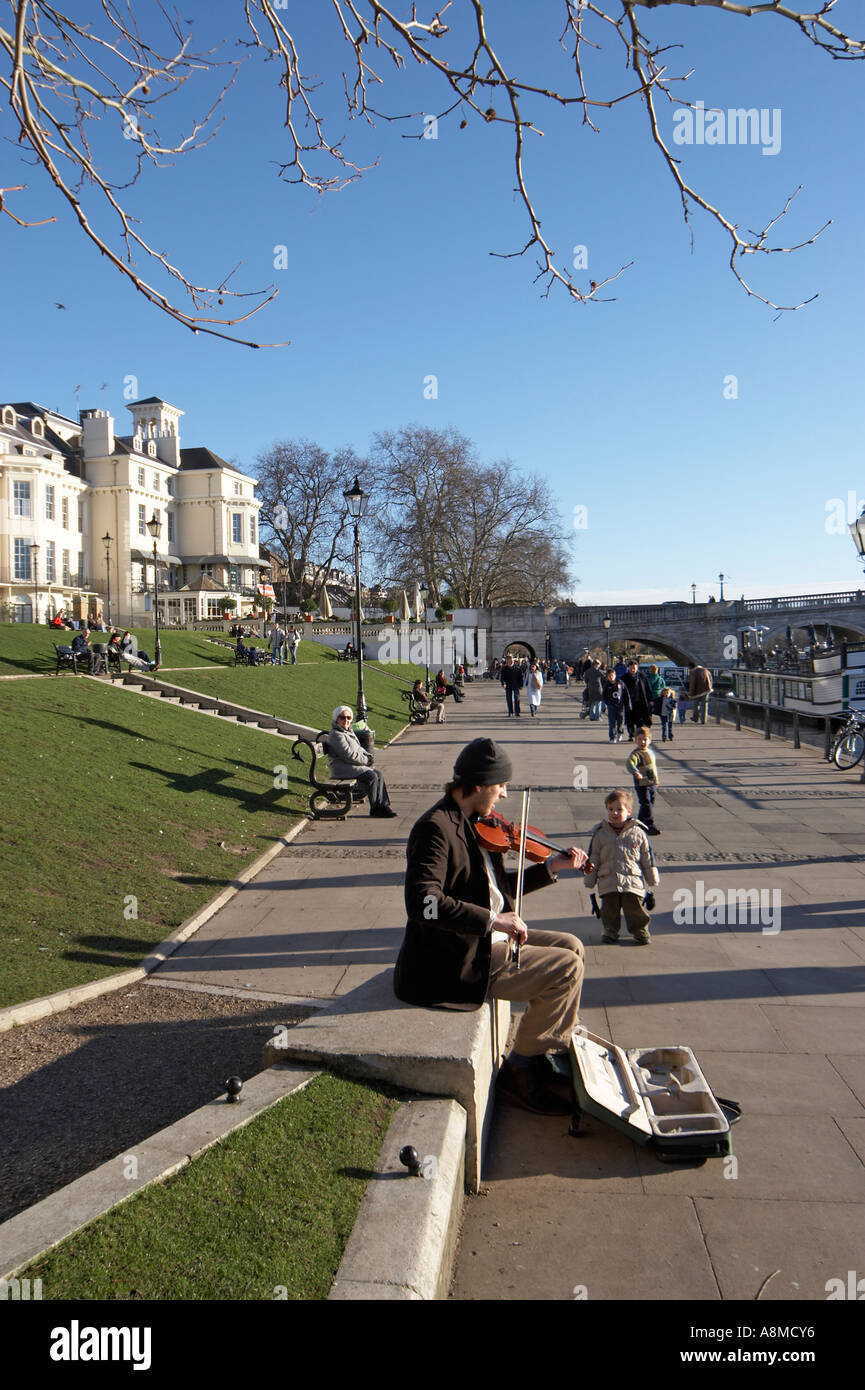 Young boy child watching a violin busker in winter sunshine Stock Photo ...