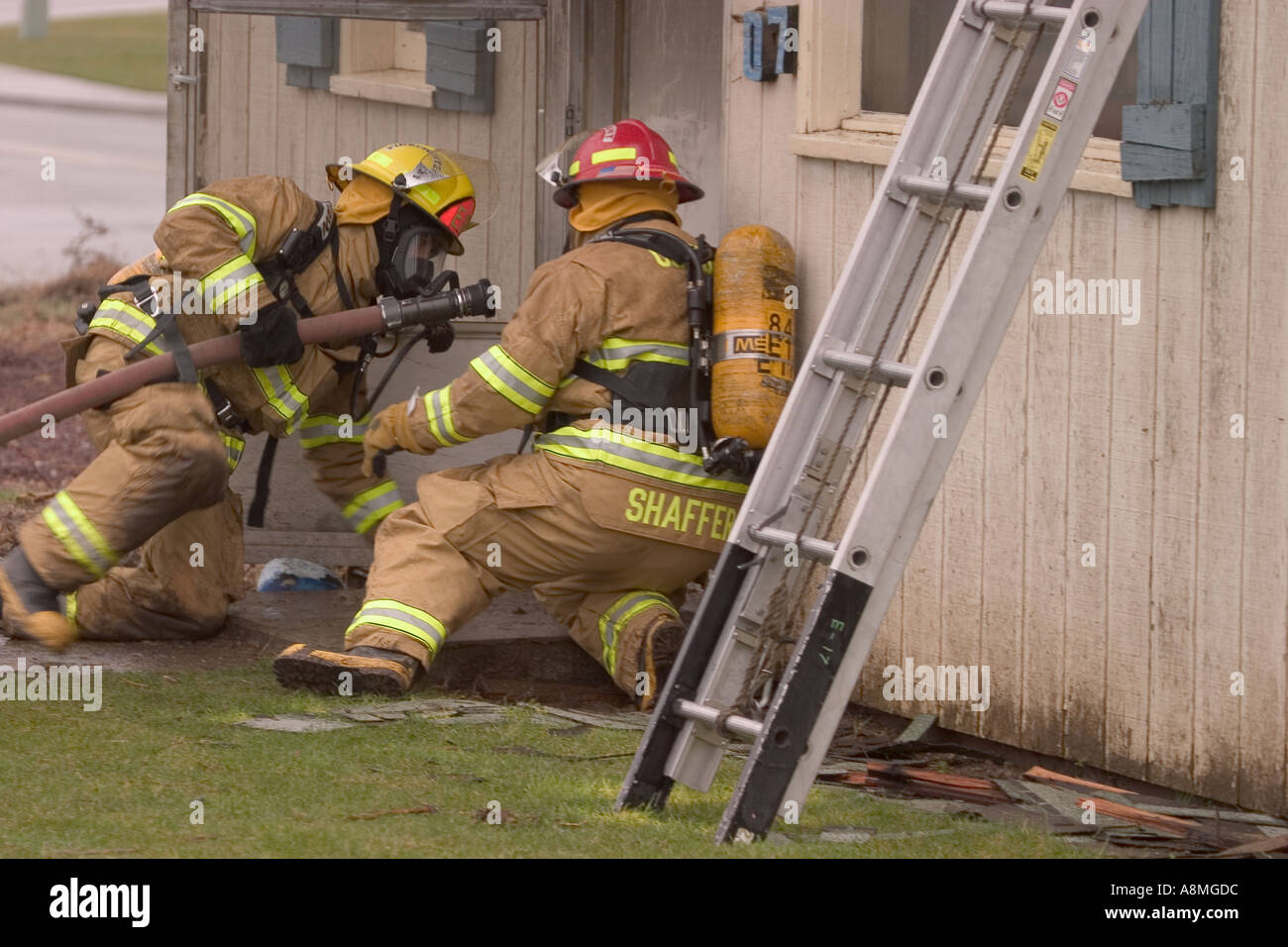 Firemen at a training session entering a house with smoke inside Stock ...