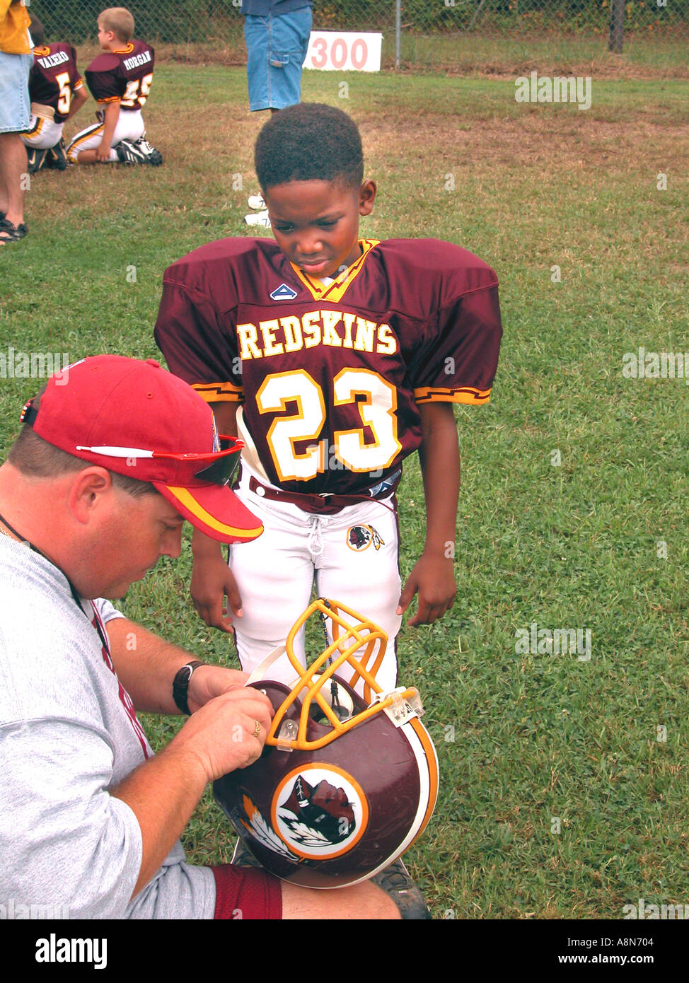 Dad s and Coaches with kids during full contact football game Stock ...
