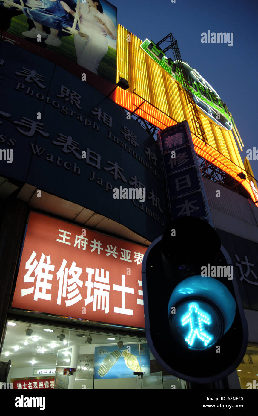 Advertisements and neon lights above a traffic light near the ...