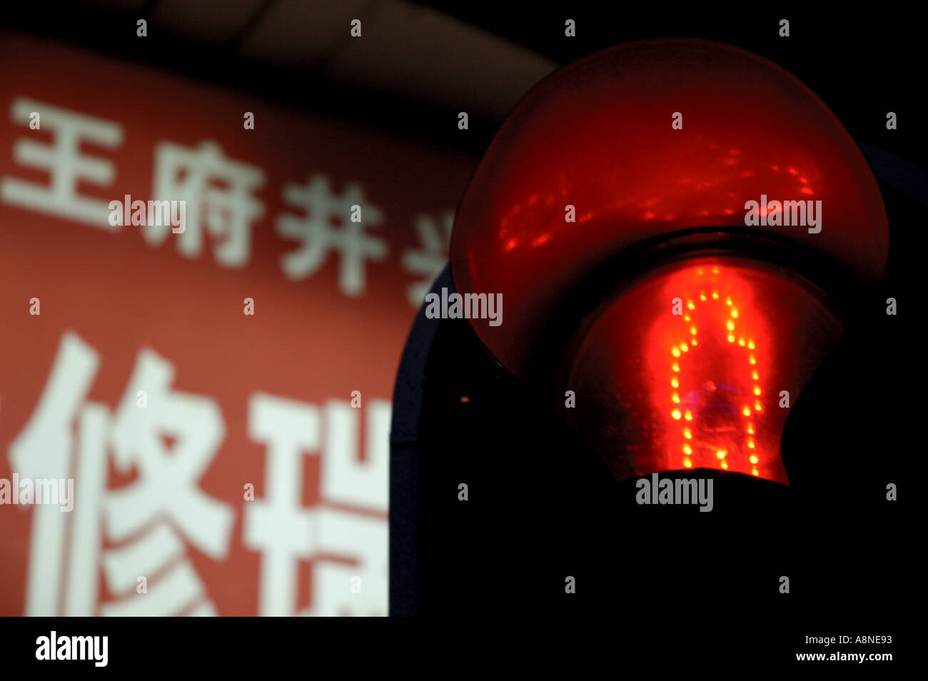 Pedestrian walking sign illuminated at night near Wangfujing Mall ...
