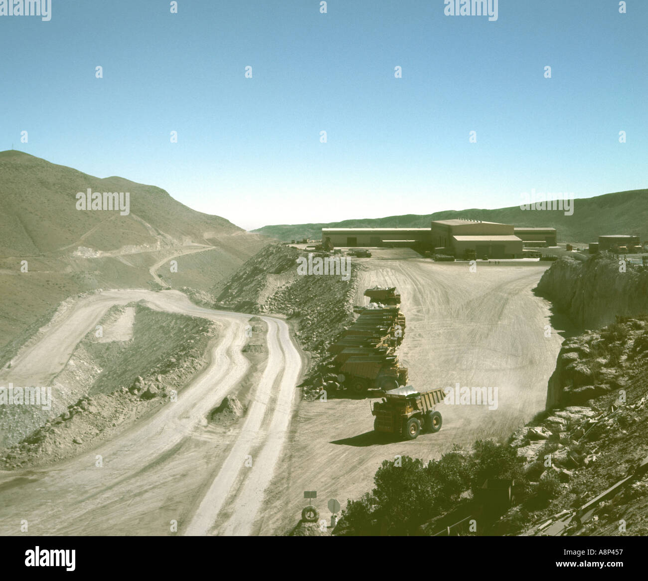 Early stages of building Cuajone copper mining complex with mine trucks ...