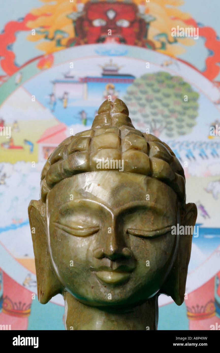 Green jade Buddha head against complete image of buddhist wheel of life ...