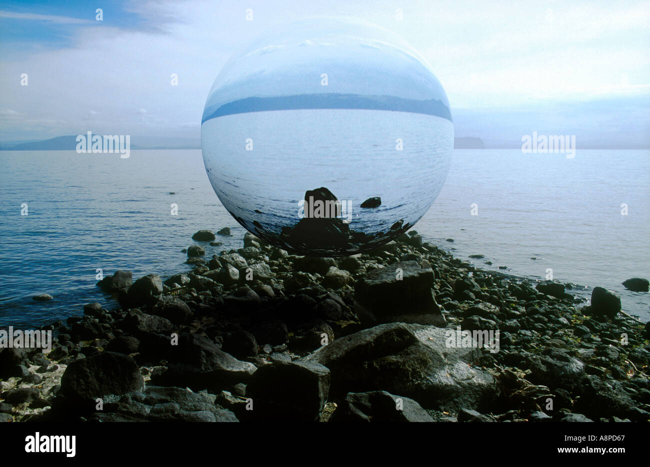 Reflective sphere floating above a lake shore Stock Photo - Alamy