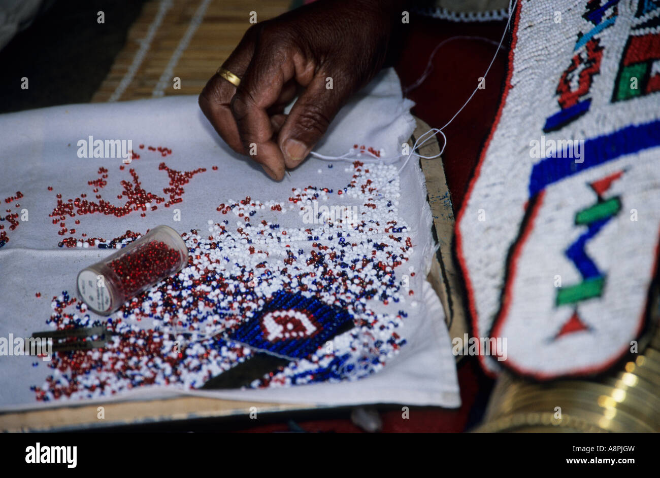 South Africa, closeup, Ndebele woman, hand threading beads onto cotton ...