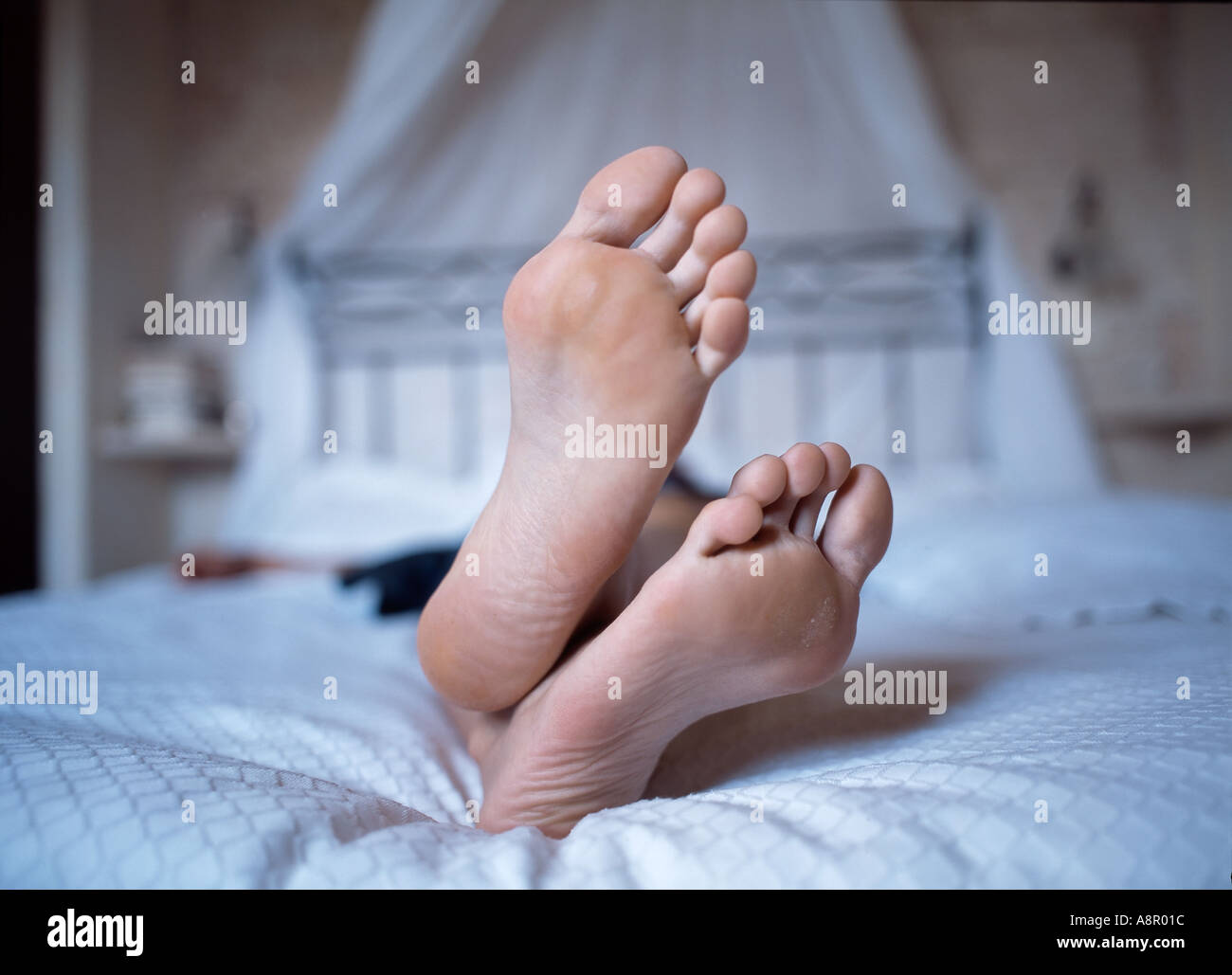 Person lying on bed, close up of feet Stock Photo - Alamy