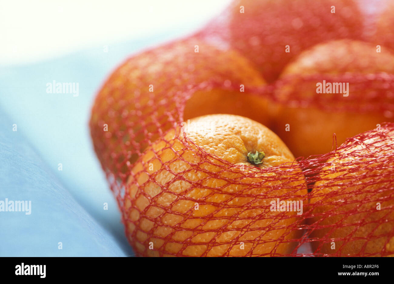 Oranges in net, close-up Stock Photo - Alamy
