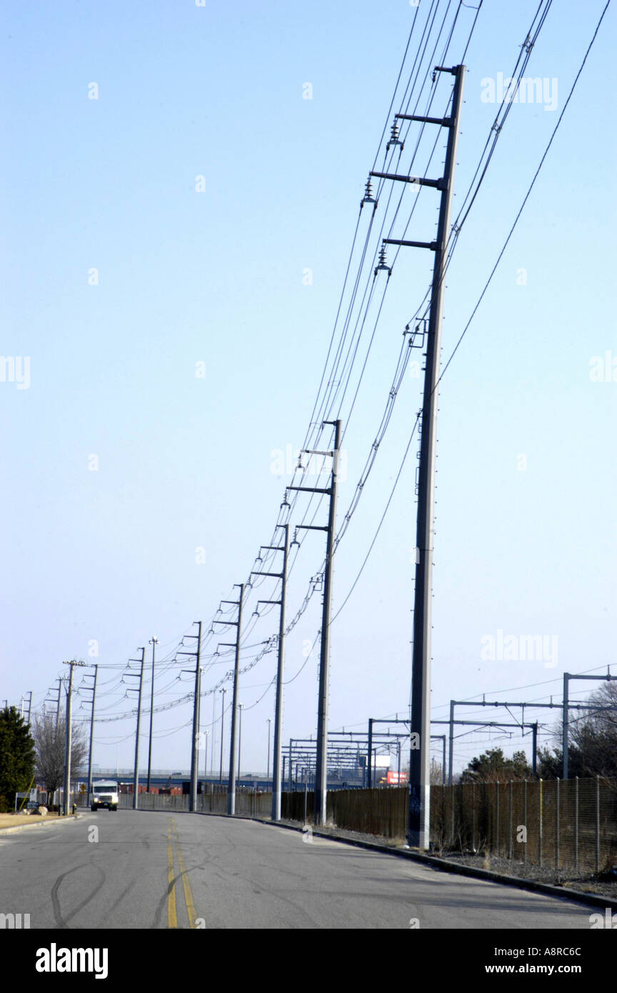 High voltage transmission lines along road Stock Photo - Alamy