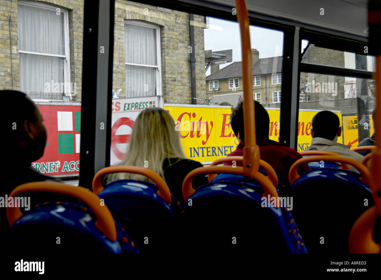 Top floor of double deck London bus with passengers looking through the ...