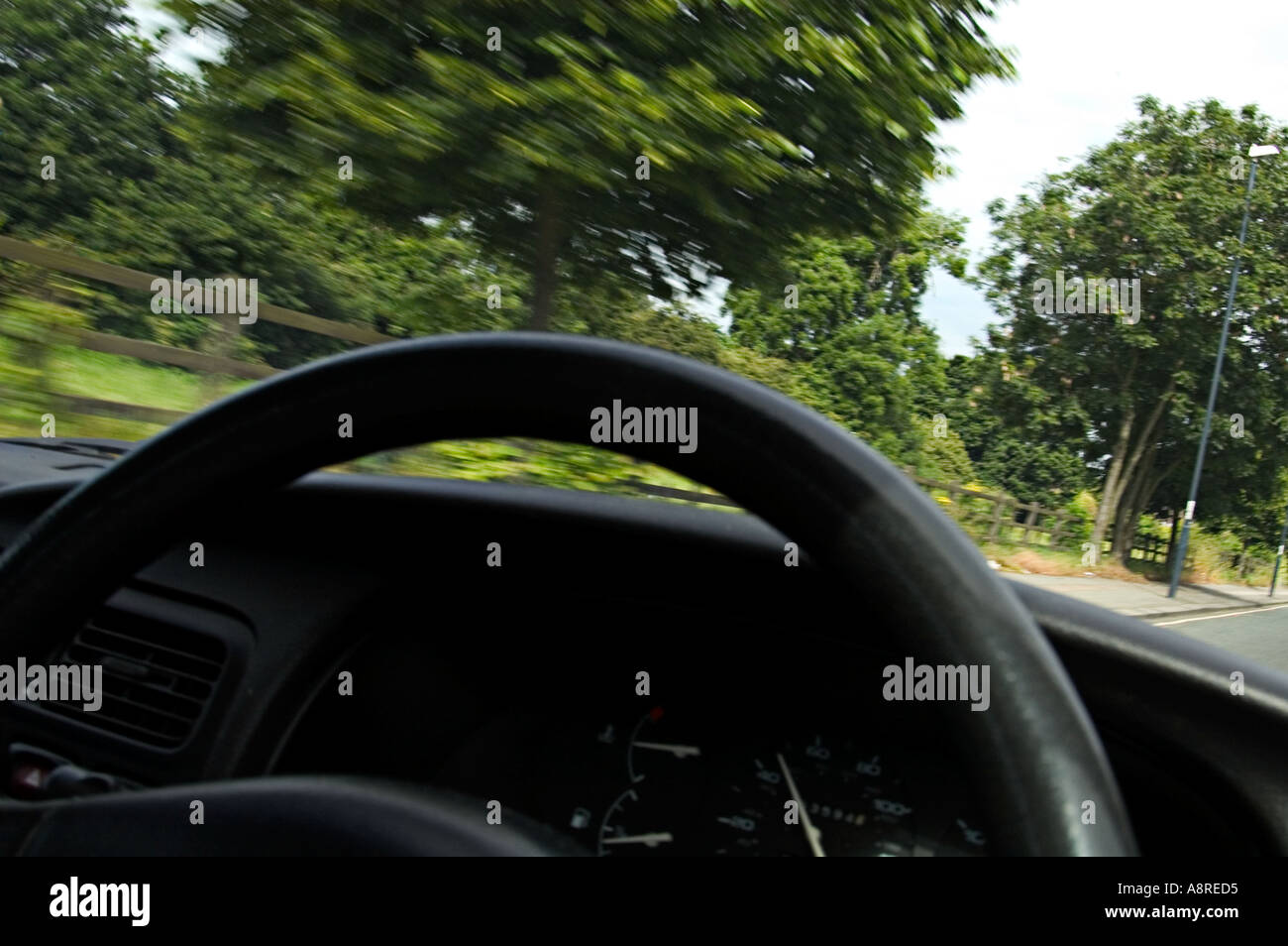Drivers view of steering wheel and landscape through windscreen of ...