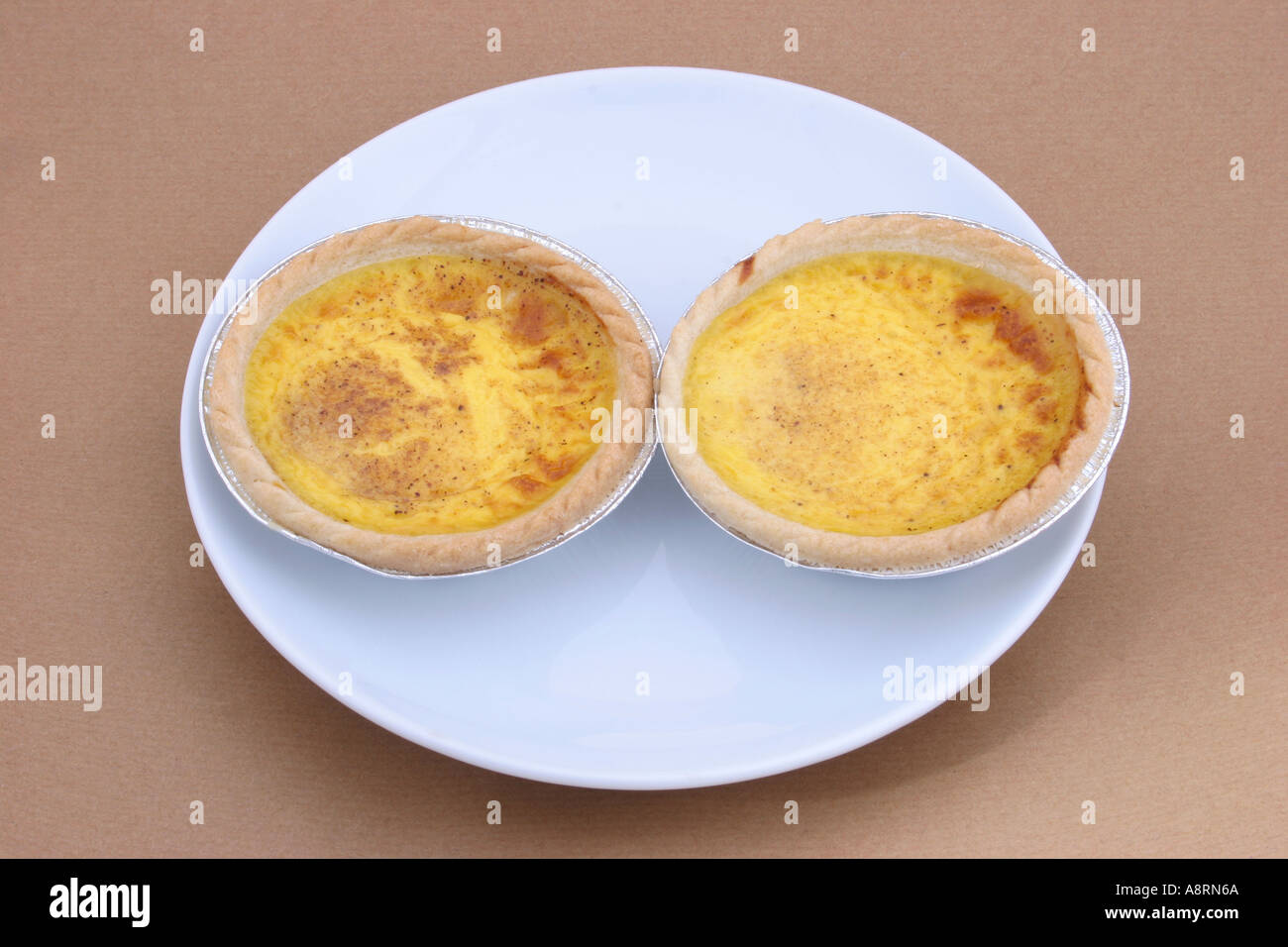 custard tarts still life on a tan colored backdrop Stock Photo - Alamy