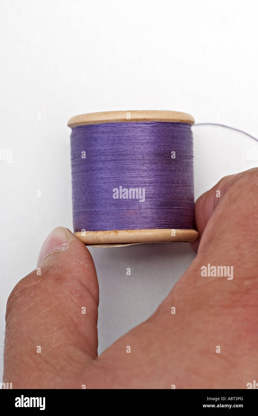 Hand Holding Spool of Dark Lilac Mercerised Cotton Thread Made In ...