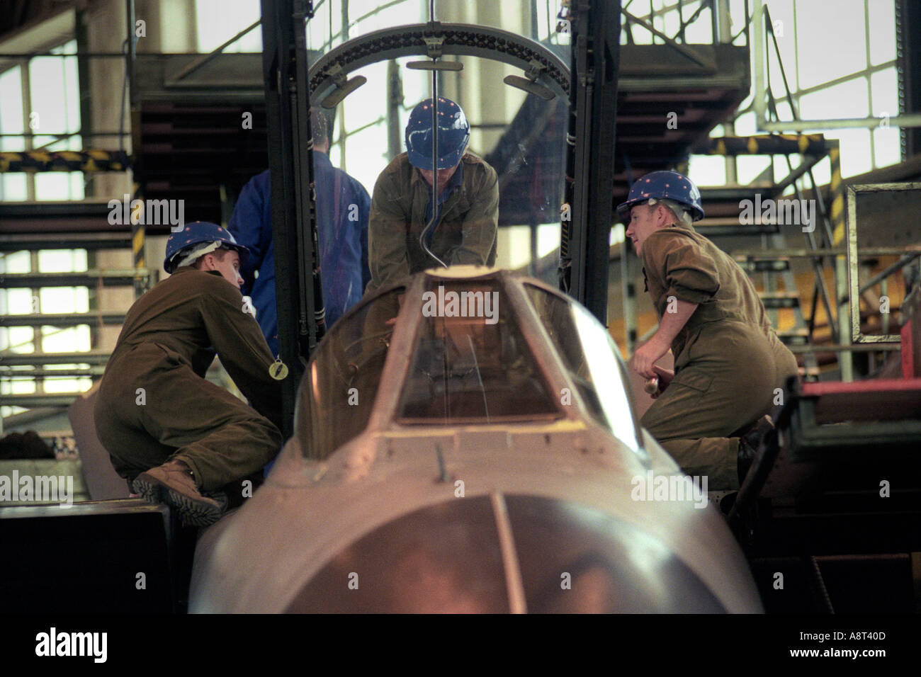 Technicians work on a Tornado GR4 fighter jet in maintenance hanger at ...