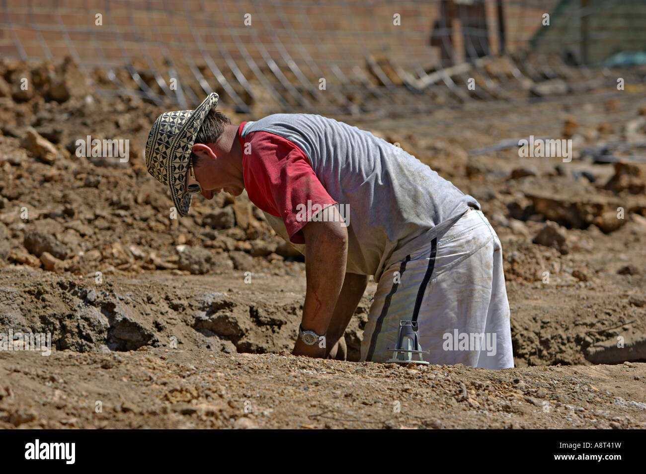 Construction worker placing support feet under reinforced steel for ...