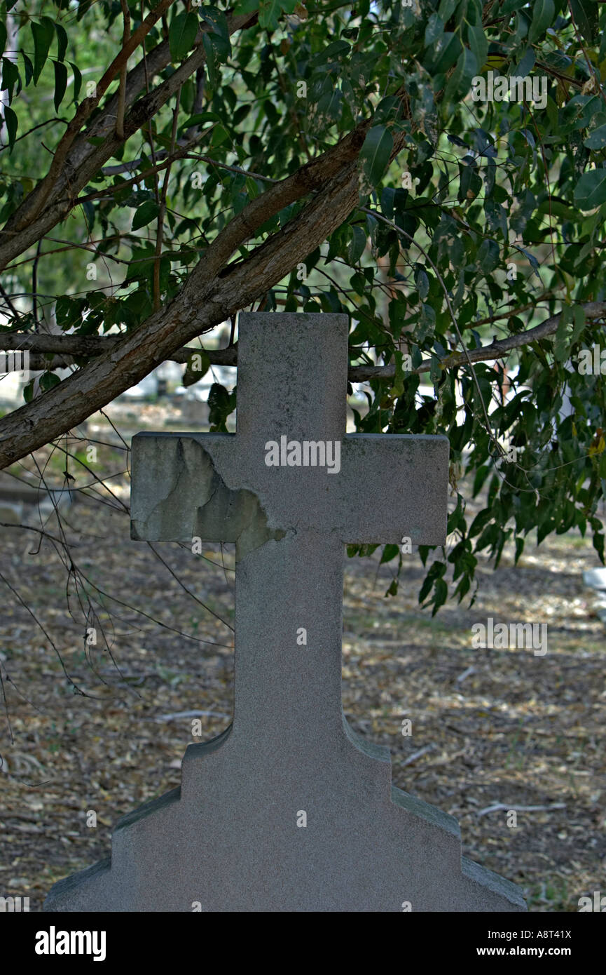 Gravestone crucifix resting in the shade under a gum tree Stock Photo ...