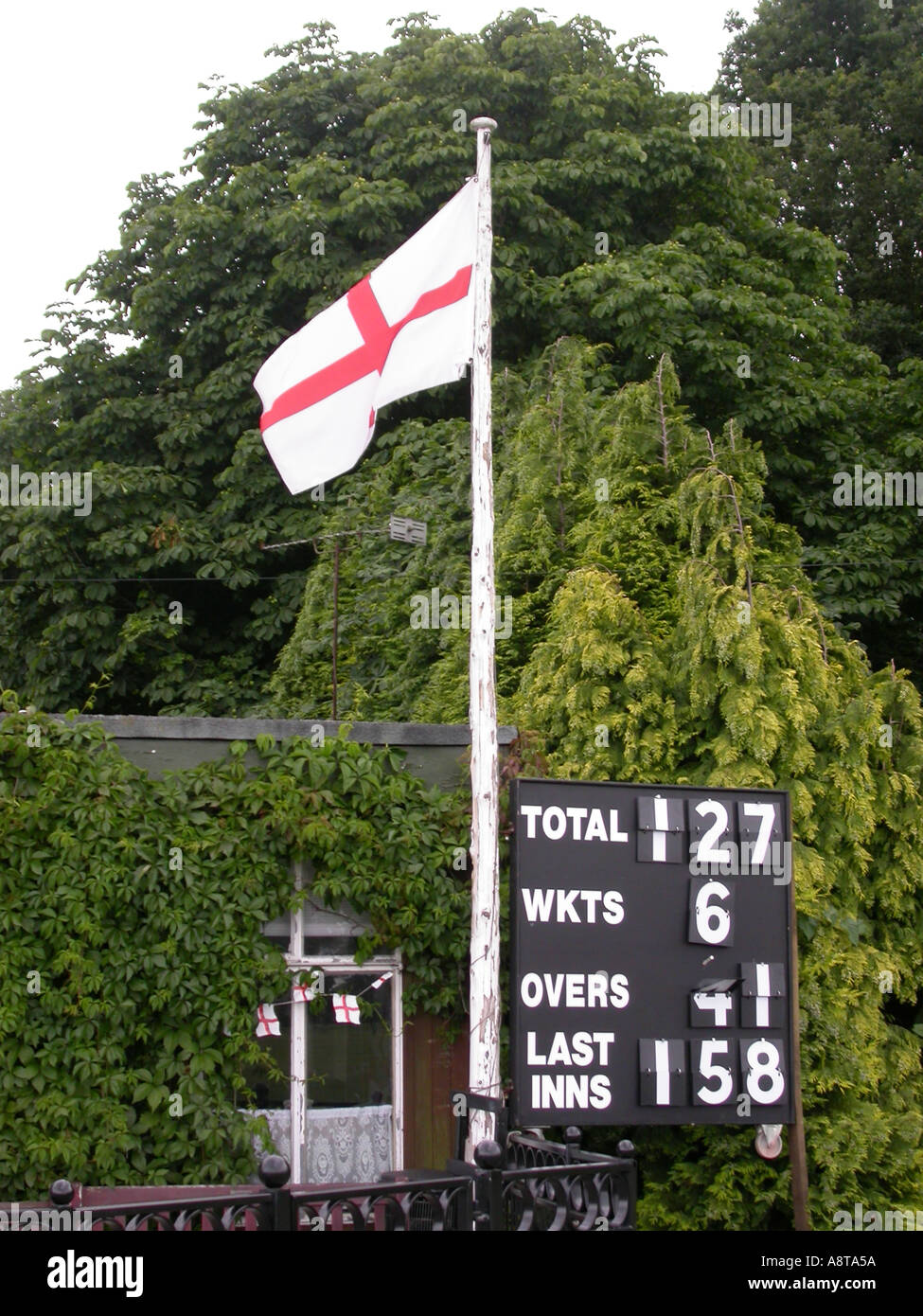 Flag of Saint George and cricket scoreboard West End village green ...