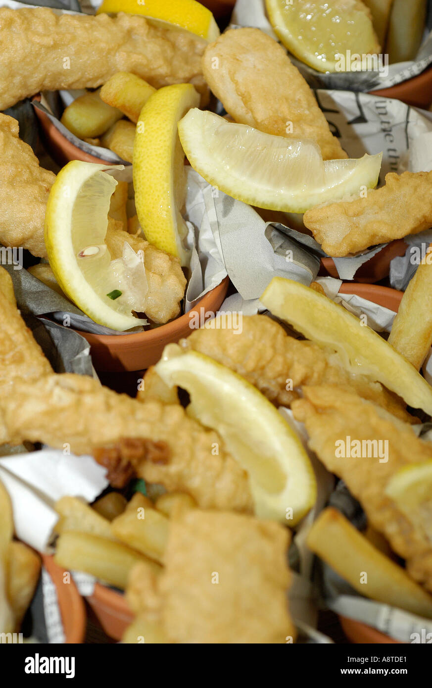 Small portions of fish and chips with lemon slices served as an hors d ...