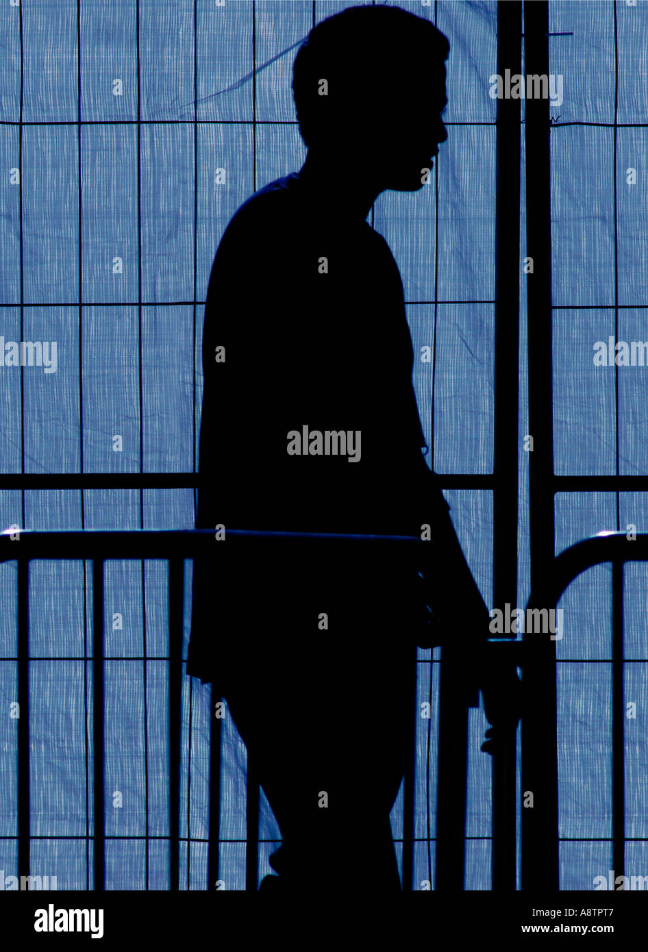 Young man walking behind a fence Stock Photo - Alamy