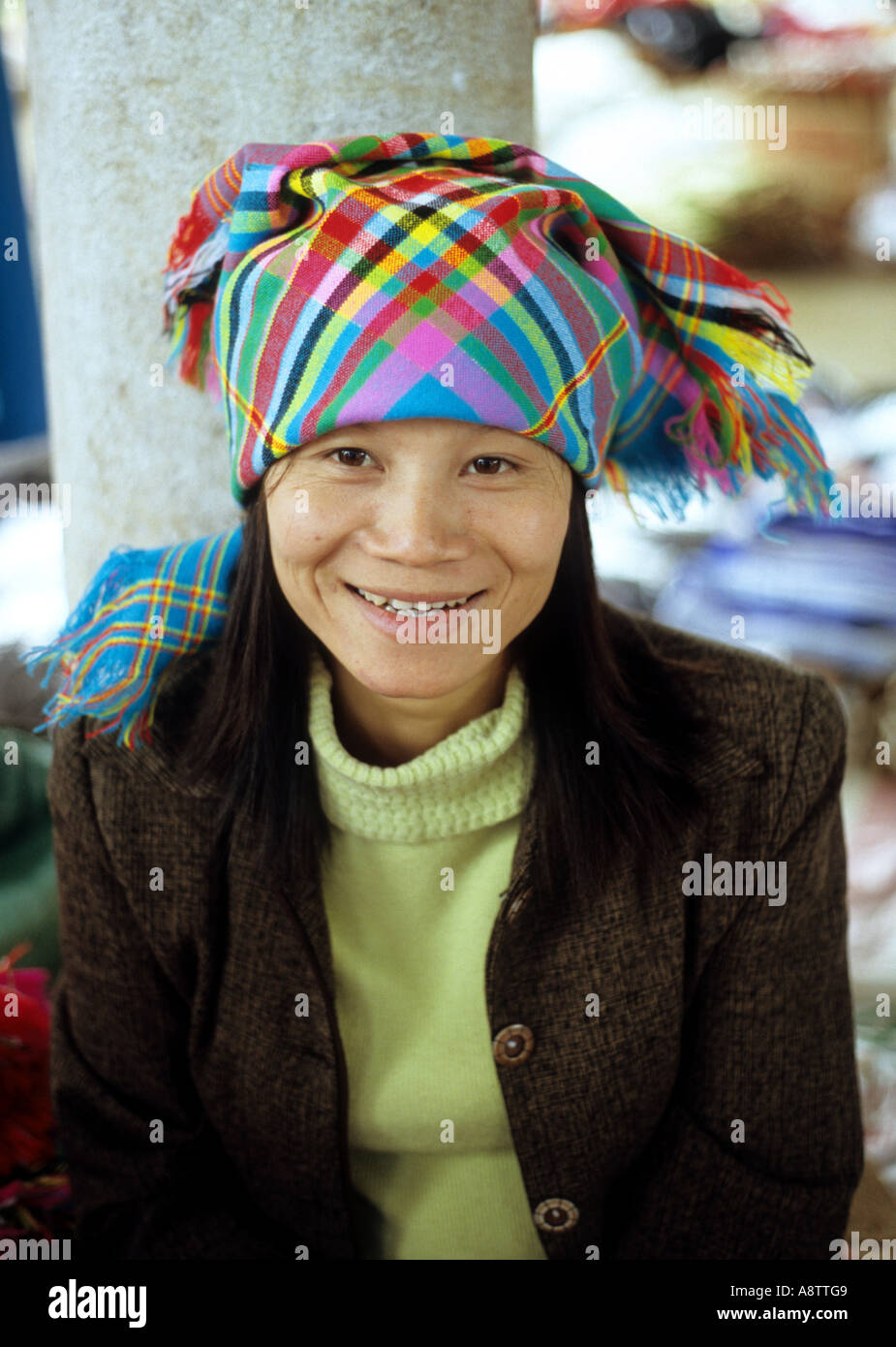 Smiling young woman demonstrating how to wear a Flower Hmong headscarf ...