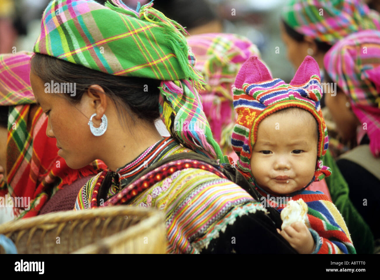 Traditionally dressed Flower Hmong woman with baby in a back carrier ...