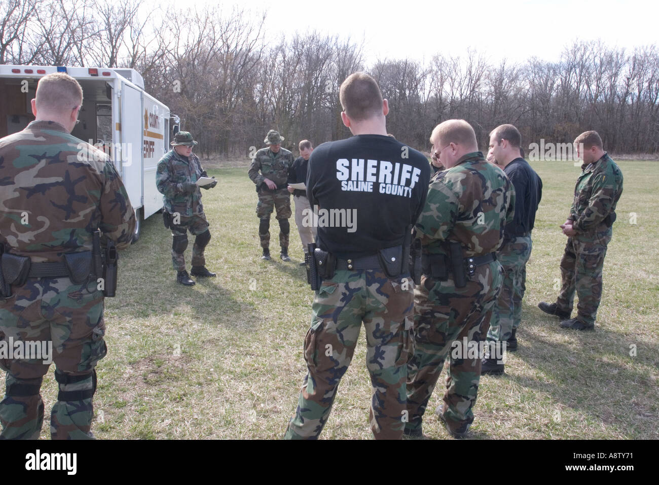 Officers and deputies in SWAT team listens as team leader is giving ...