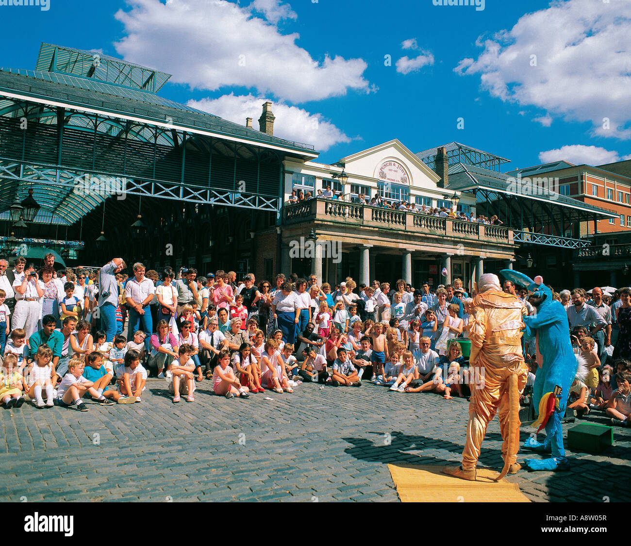 United Kingdom. England. London. Crowds watching street entertainer in ...