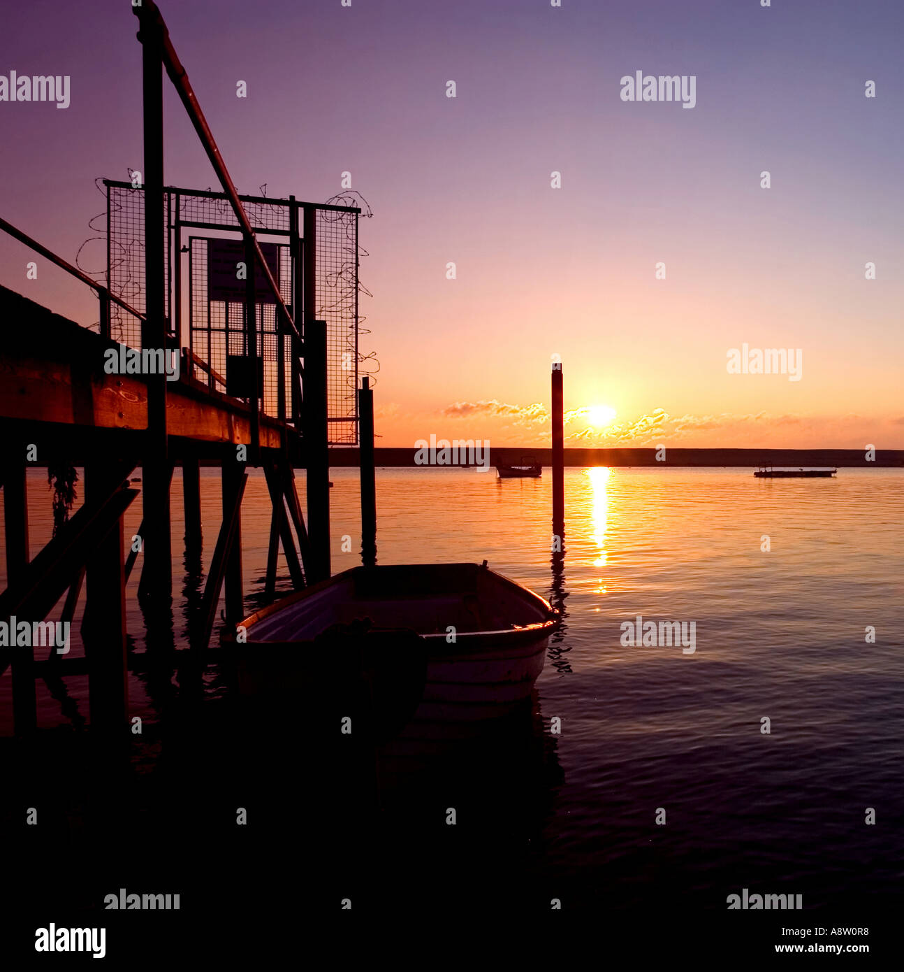 Old rowing boat on sea next to pier during sunset at Portland near ...