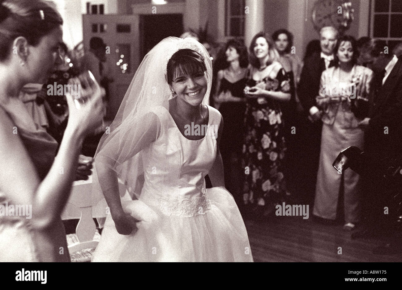 Happy bride walking through reception with guests clapping during a ...