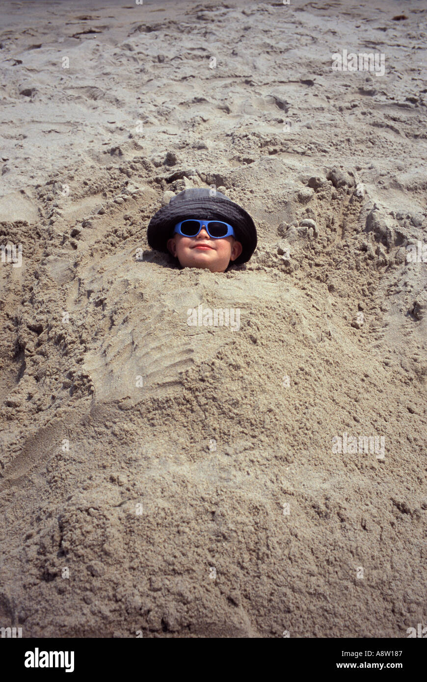 Boy buried under sand hi-res stock photography and images - Alamy