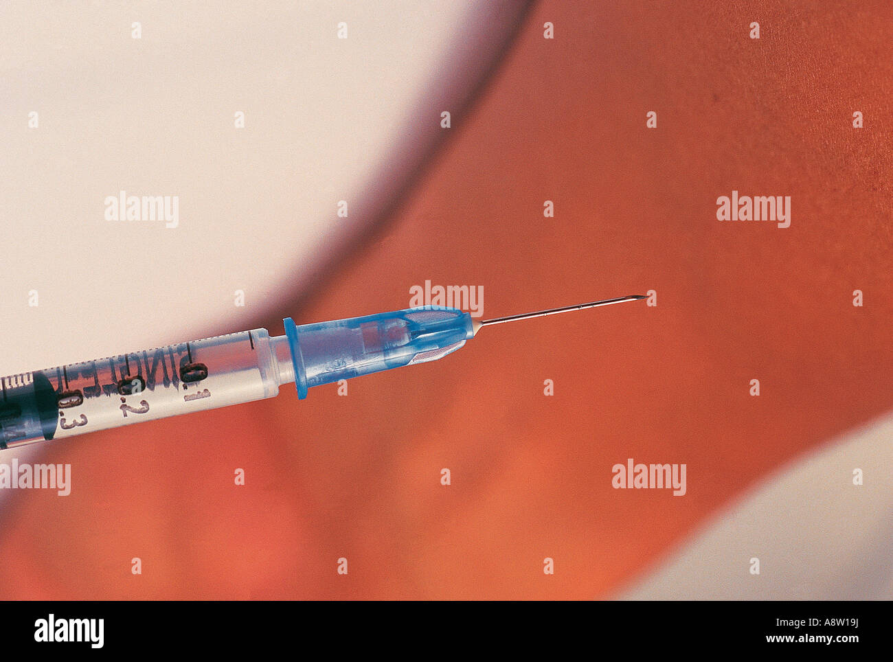 Close-up of hypodermic syringe needle with person's arm in the ...