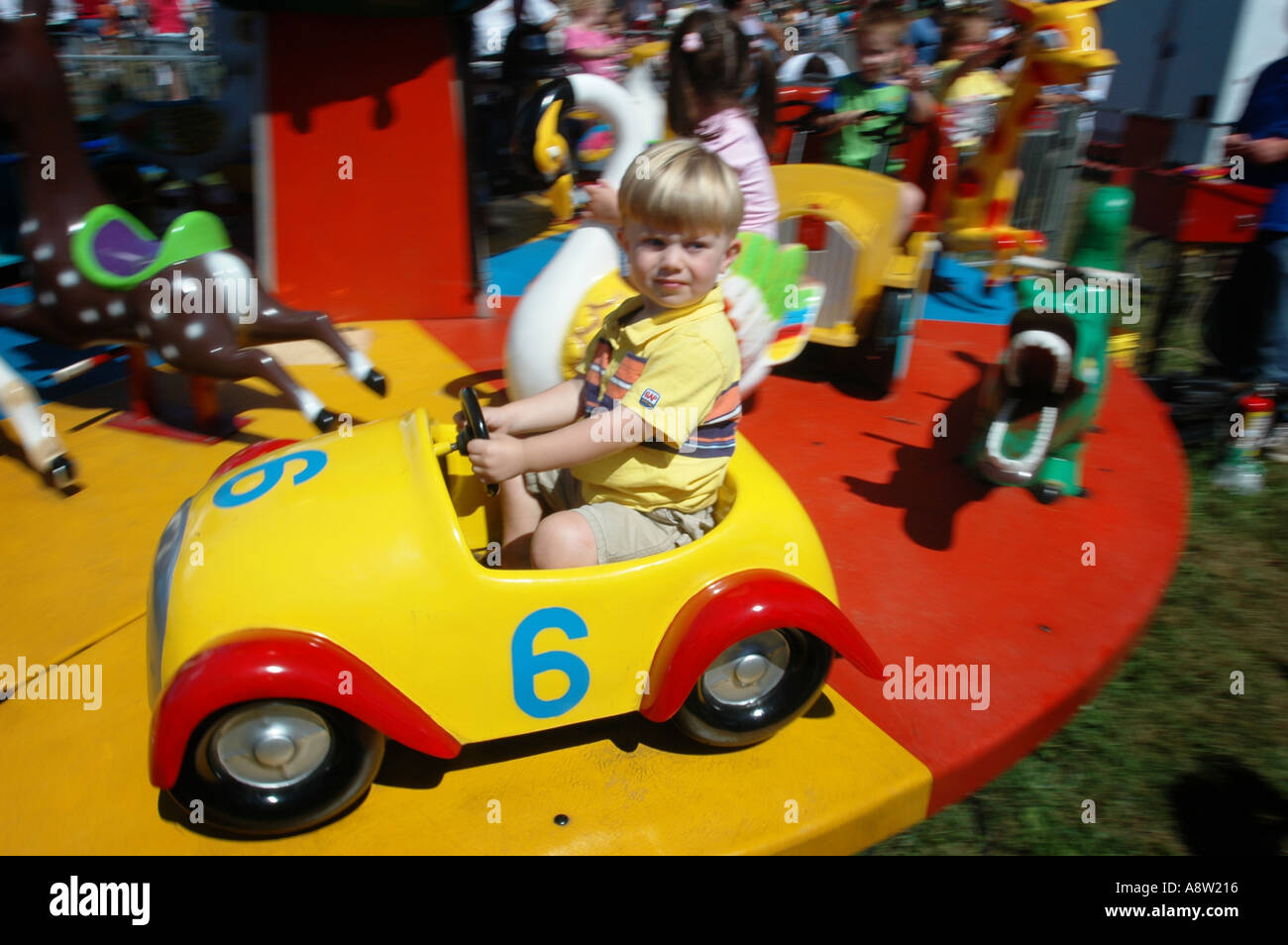 Little boy riding a carnival ride car Stock Photo - Alamy