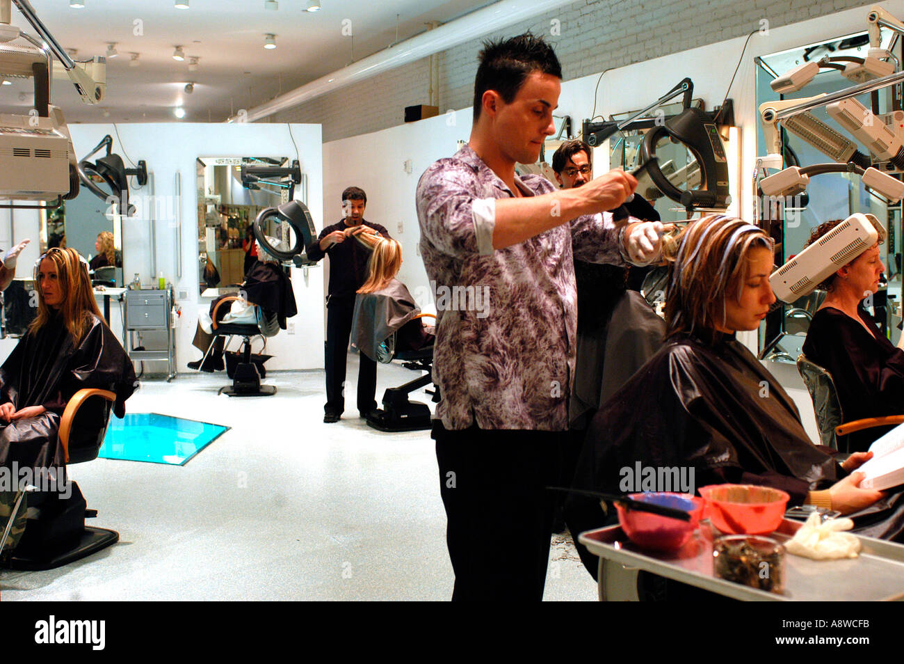 Customers at the Devachan Salon in Soho get their hair styled Stock ...