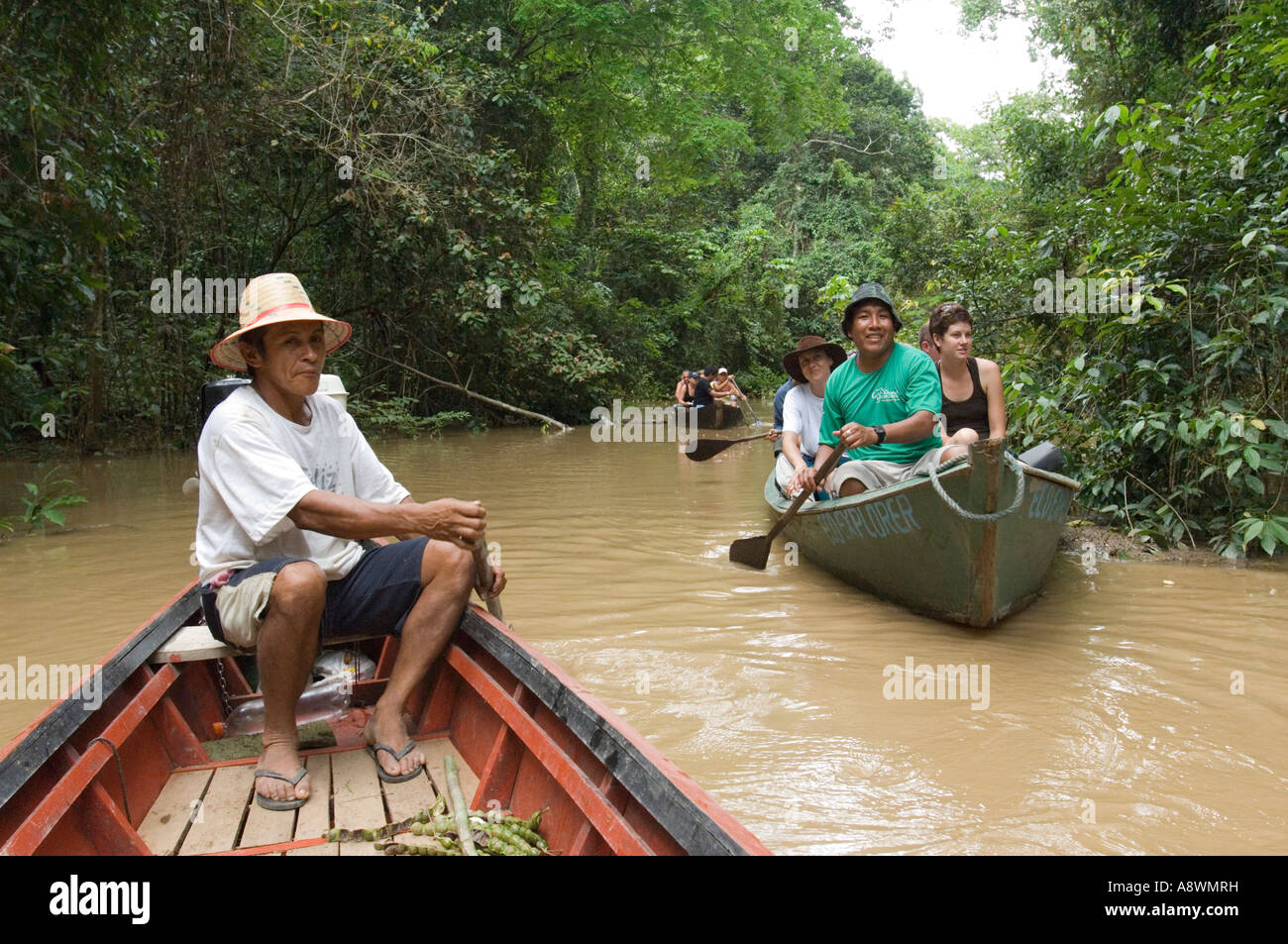 A group of tourists on a canoe trip on a tributary of the Amazon river ...