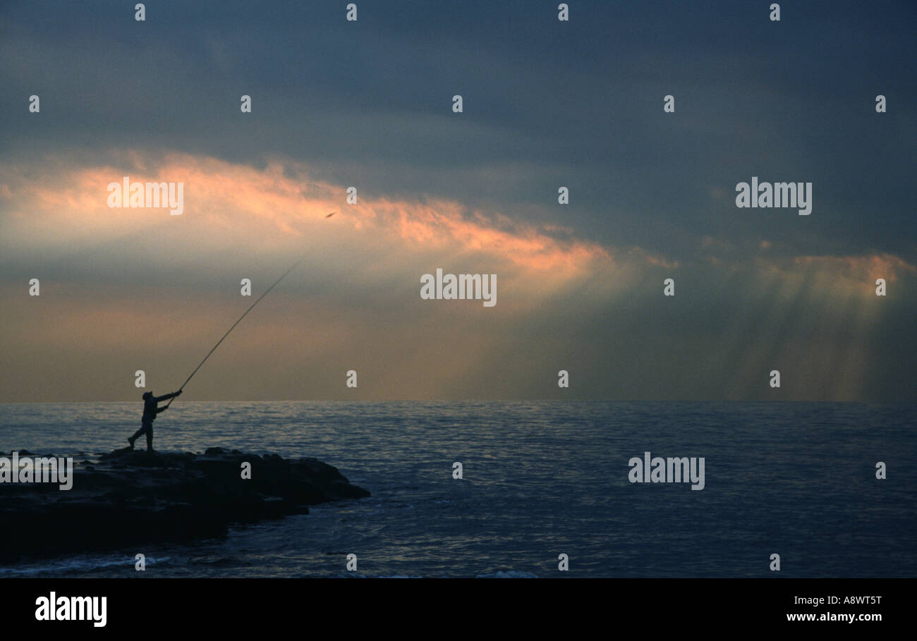 A fisherman casting a line while fishing on Enoshima Island near Tokyo ...