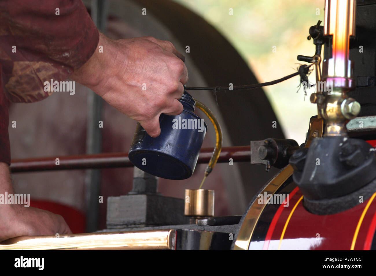Man oiling parts of steam engine Stock Photo - Alamy