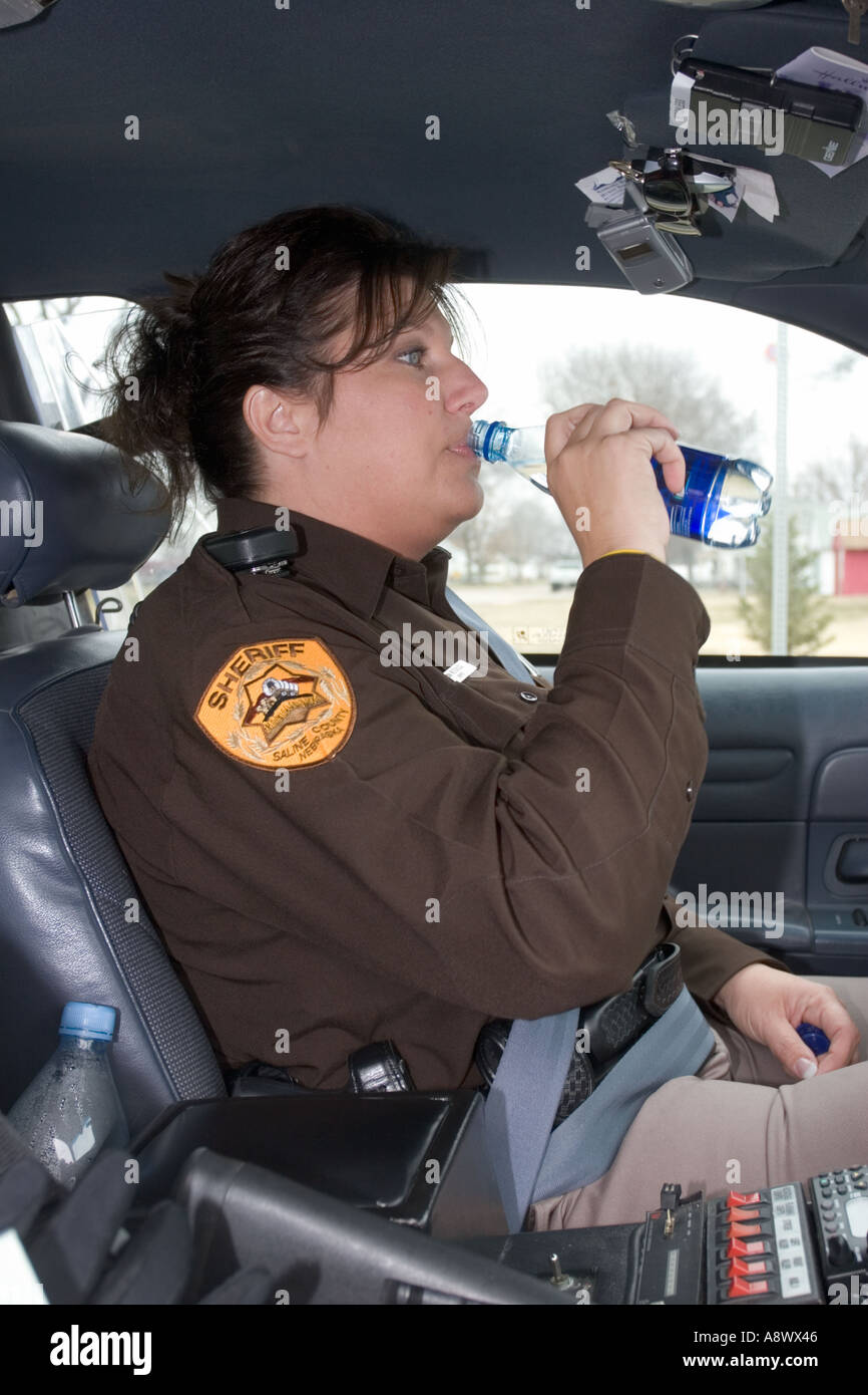 Female sheriff s deputy drinking water while taking a break in her ...