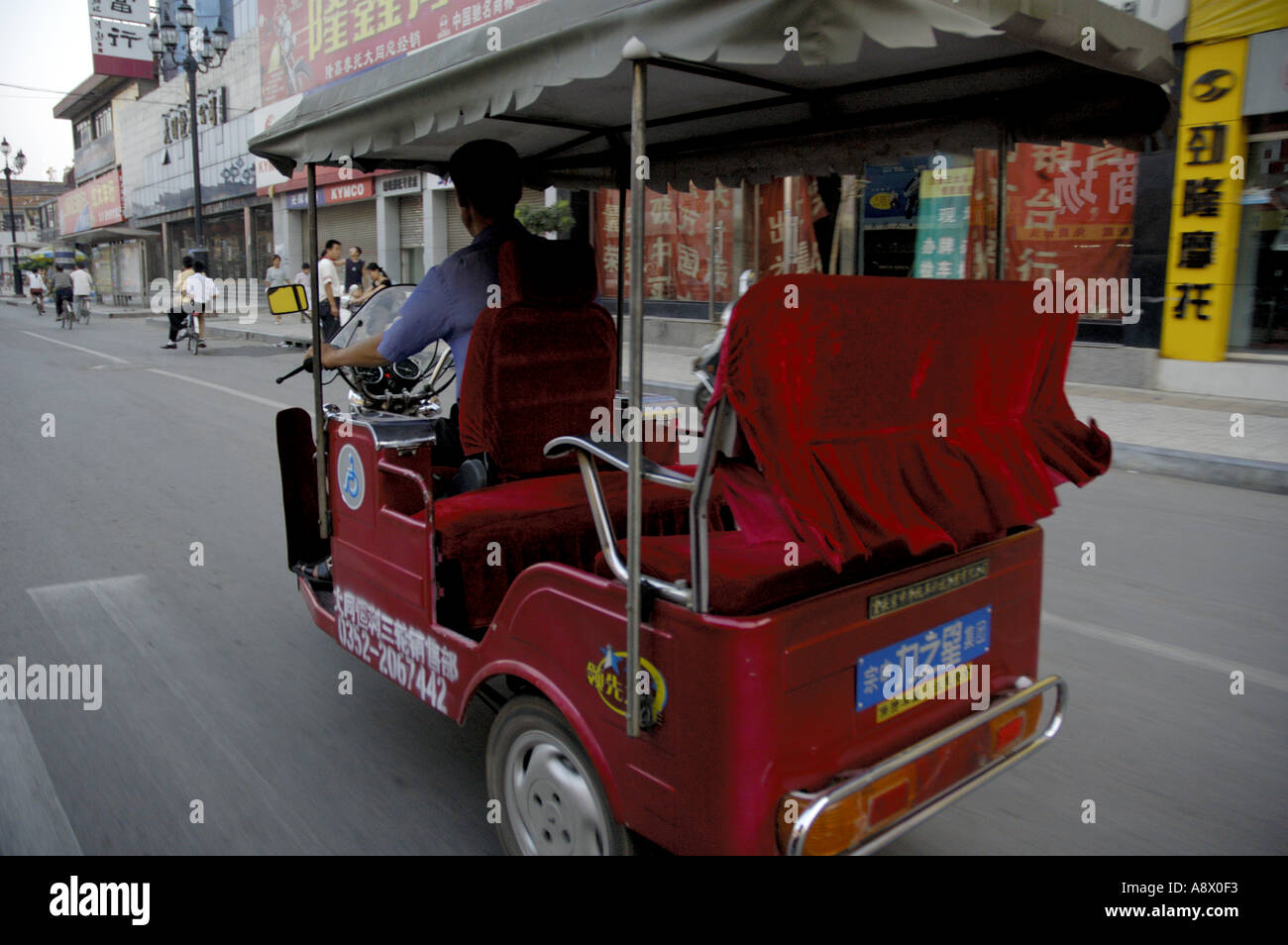 Red motor tricycle driving on a boulevard, Datong, Shanxi, China Stock ...