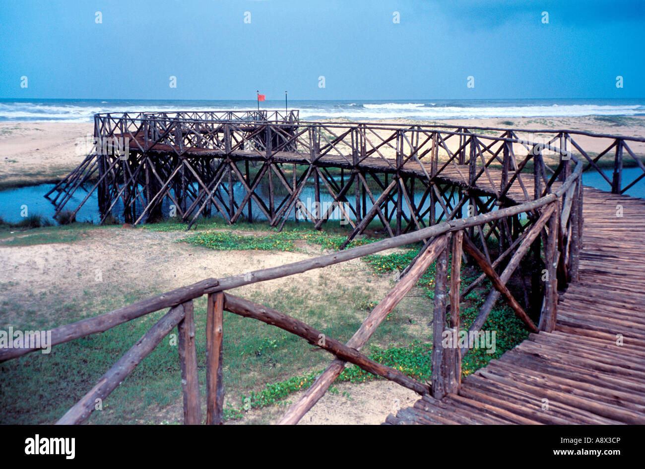 Wooden bridge from a tourist resort leading to sandy beach Varca beach ...