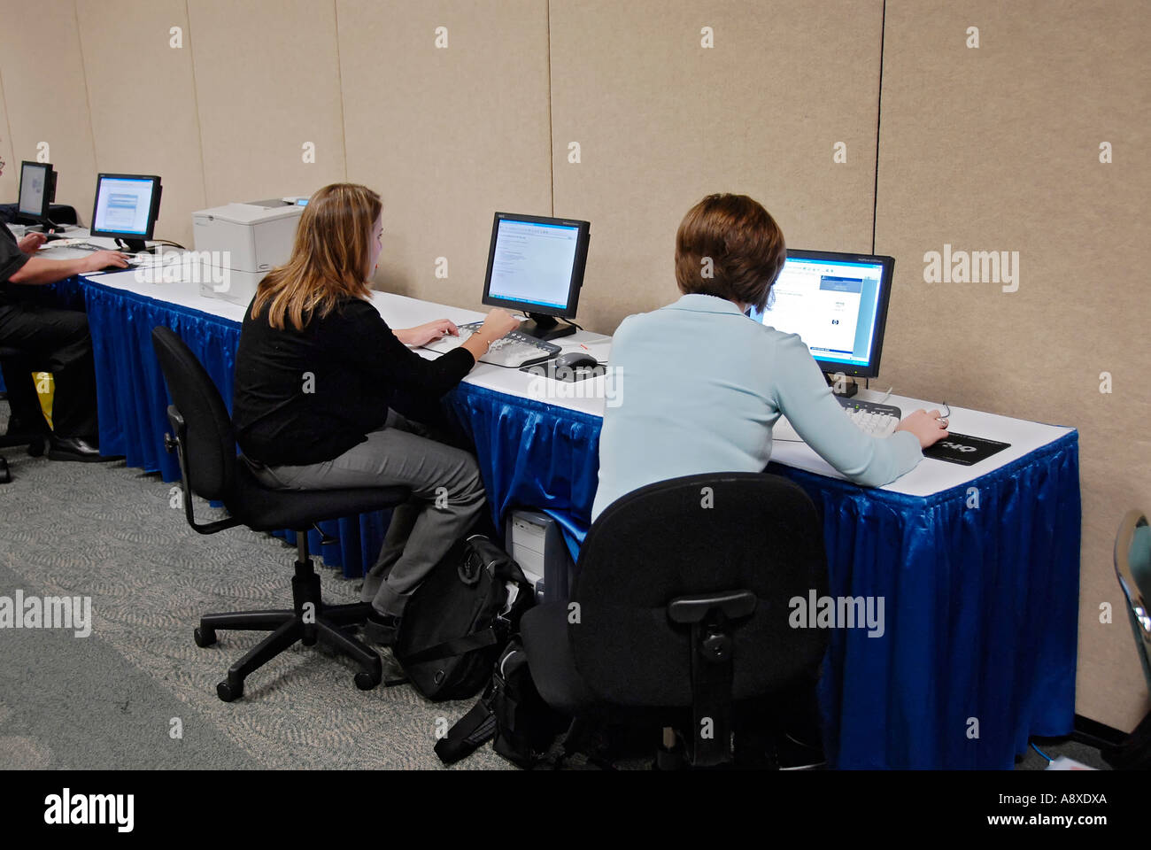 Members of the media press in a room full of computers using the latest ...