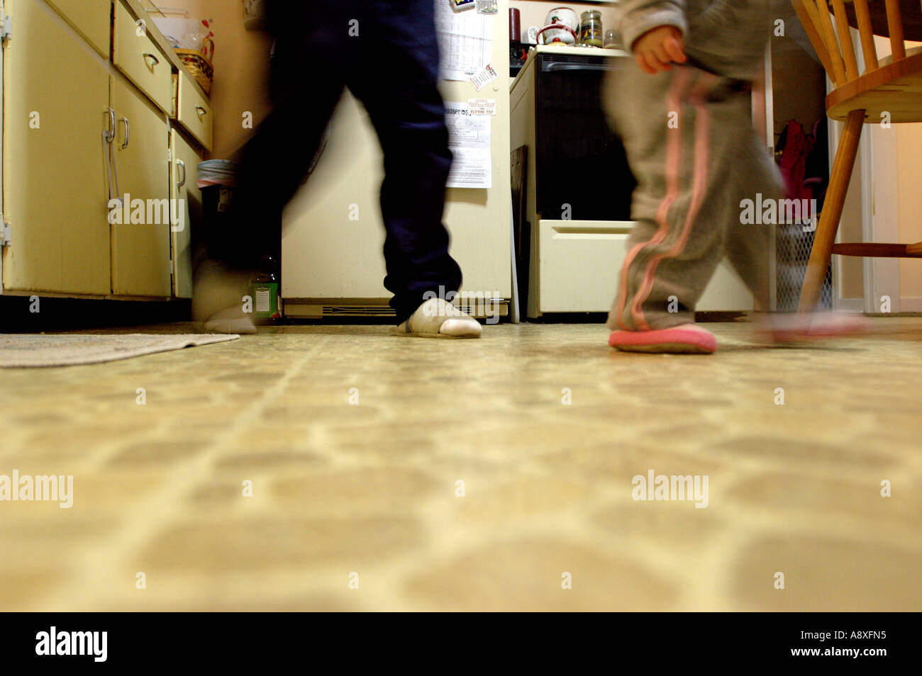 Busy feet in the kitchen. A mother and child walk across the kitchen ...