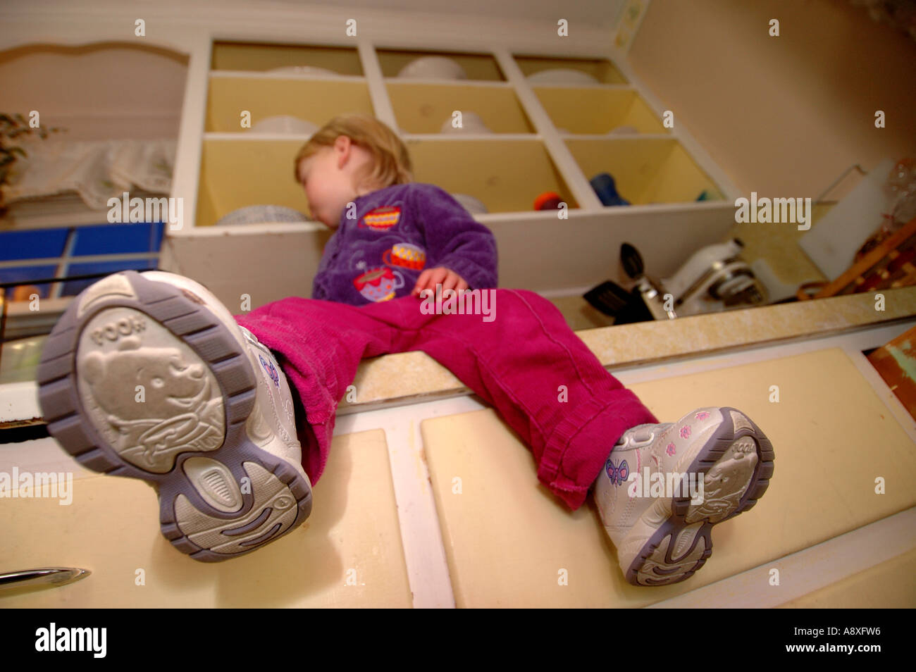 A child sits on the kitchen counter Stock Photo - Alamy
