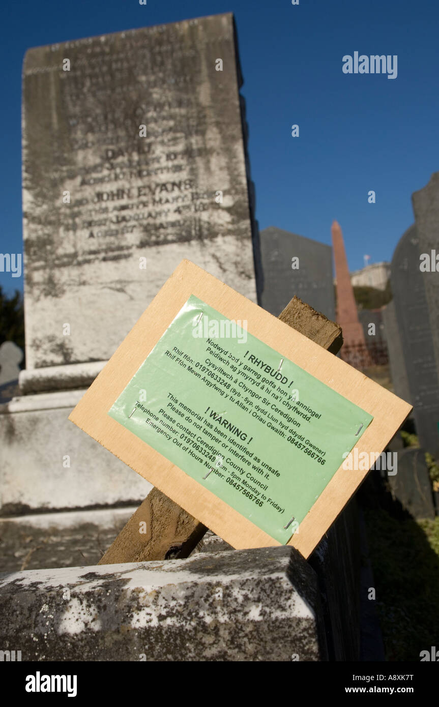Health and safety notice on crooked gravestone giving warning of unsafe ...
