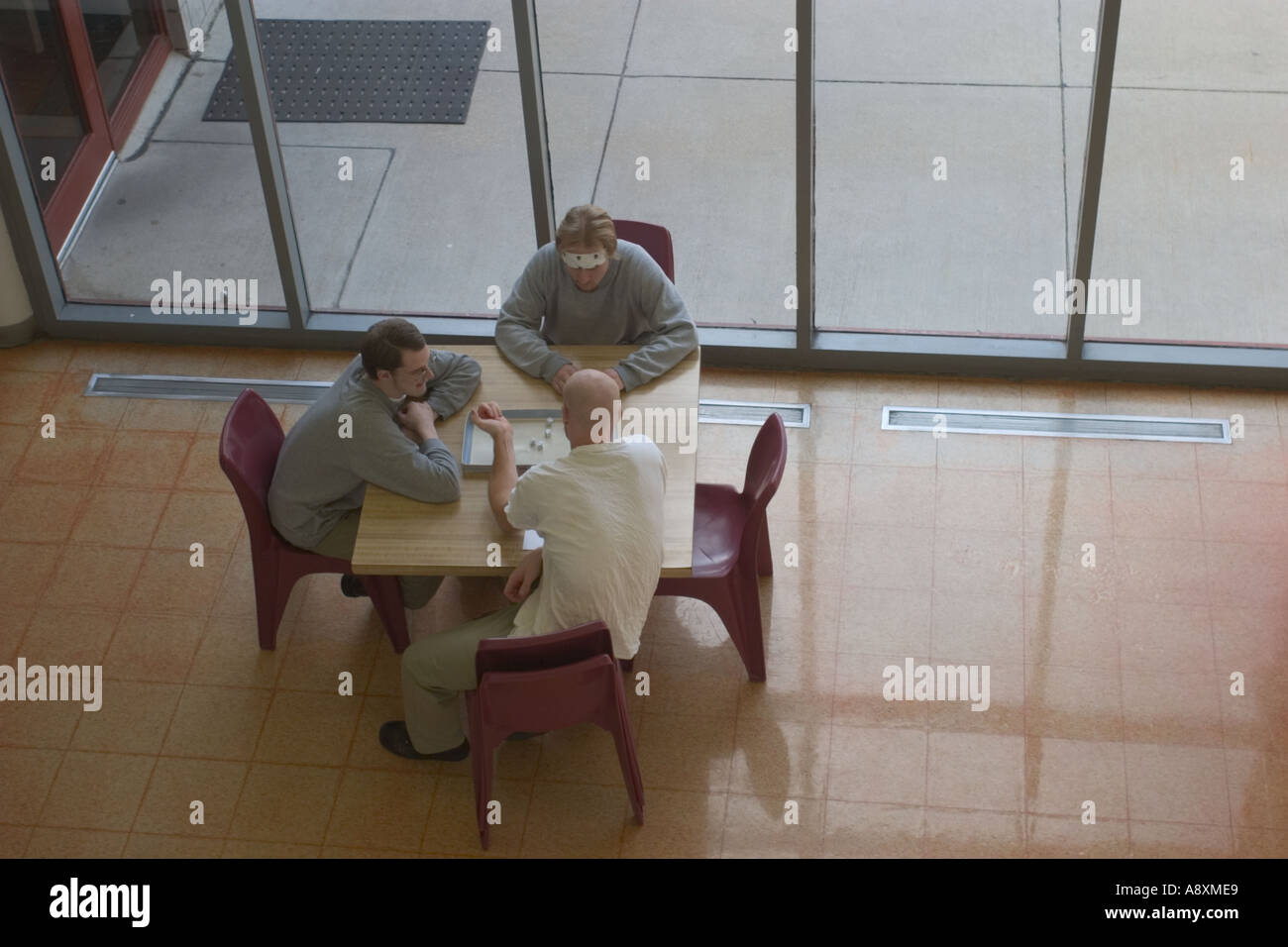 Group of prison inmates playing game in recreational area in their cell ...
