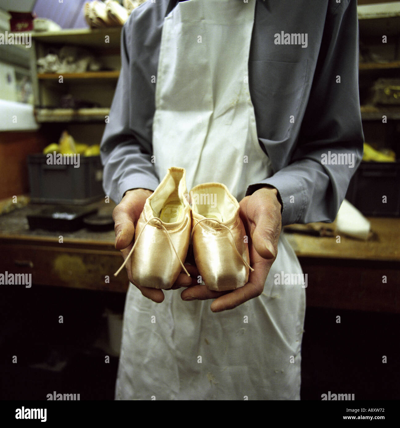 a pair of hand made ballet shoes held by the man who made them in the ...