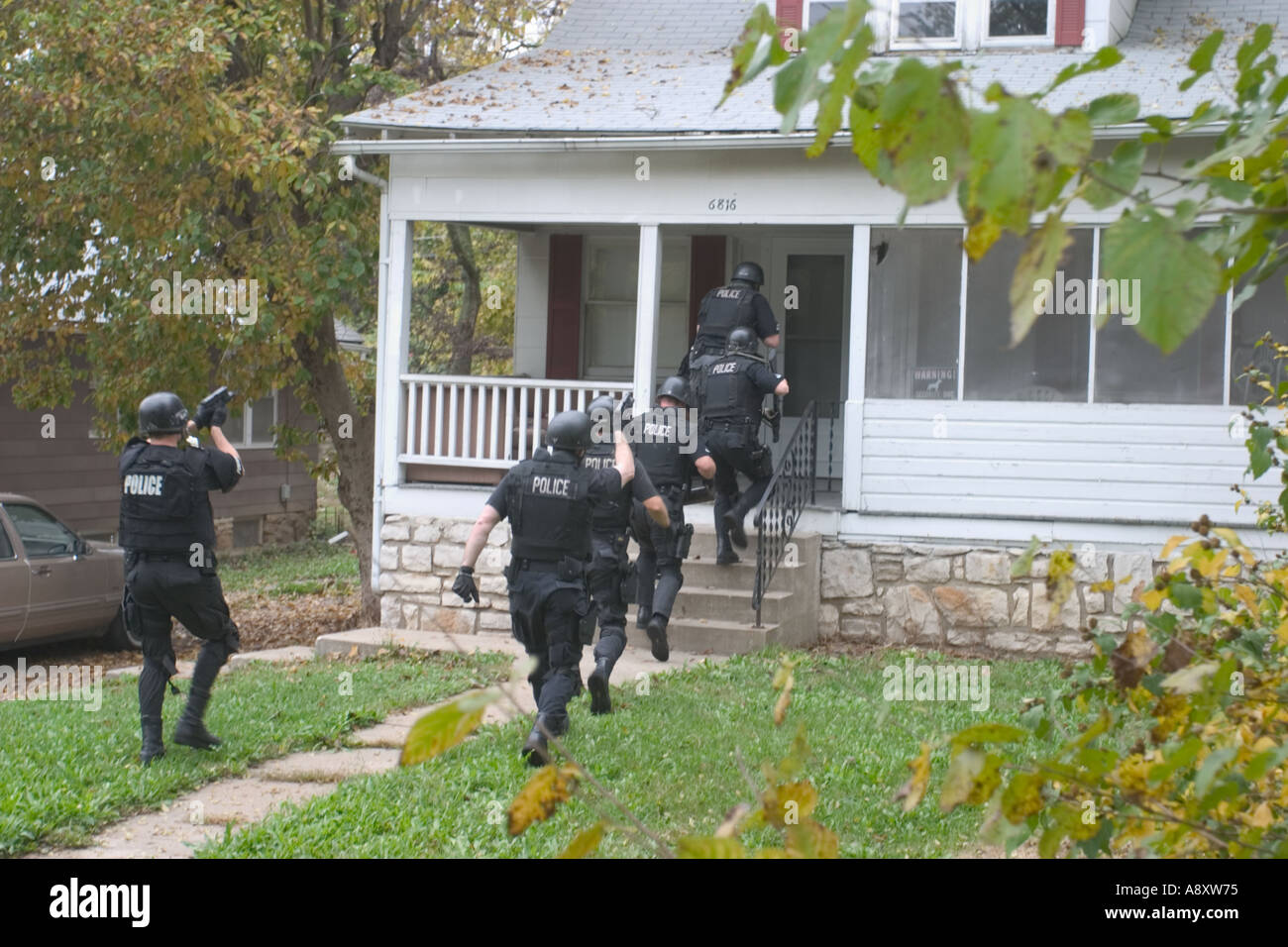 Police tactical team moving in to serve a high risk drug related search ...