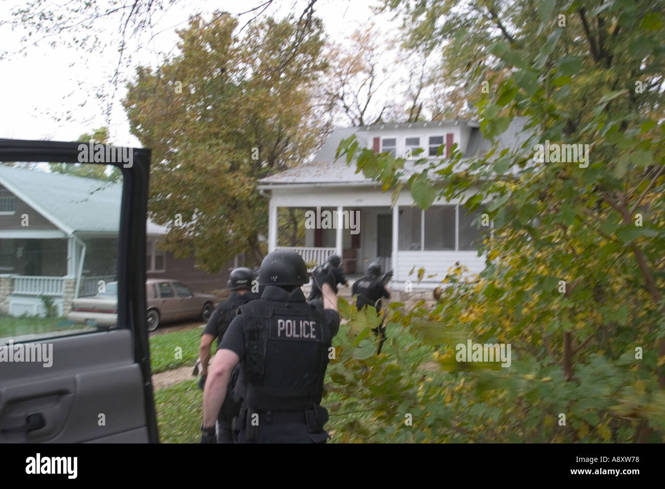 Police tactical team moving in to serve a high risk drug related search ...